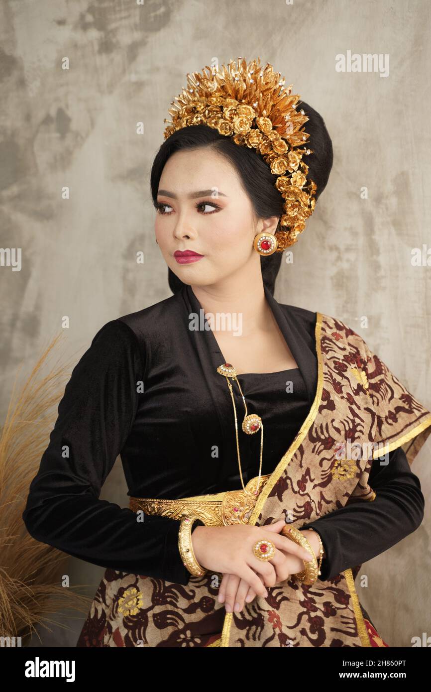 Woman wearing Endek woven fabric and Balinese Kebaya Stock Photo - Alamy