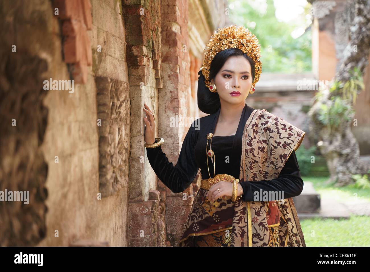 Asian woman wearing Balinese kebaya next to a relief wall Stock Photo ...