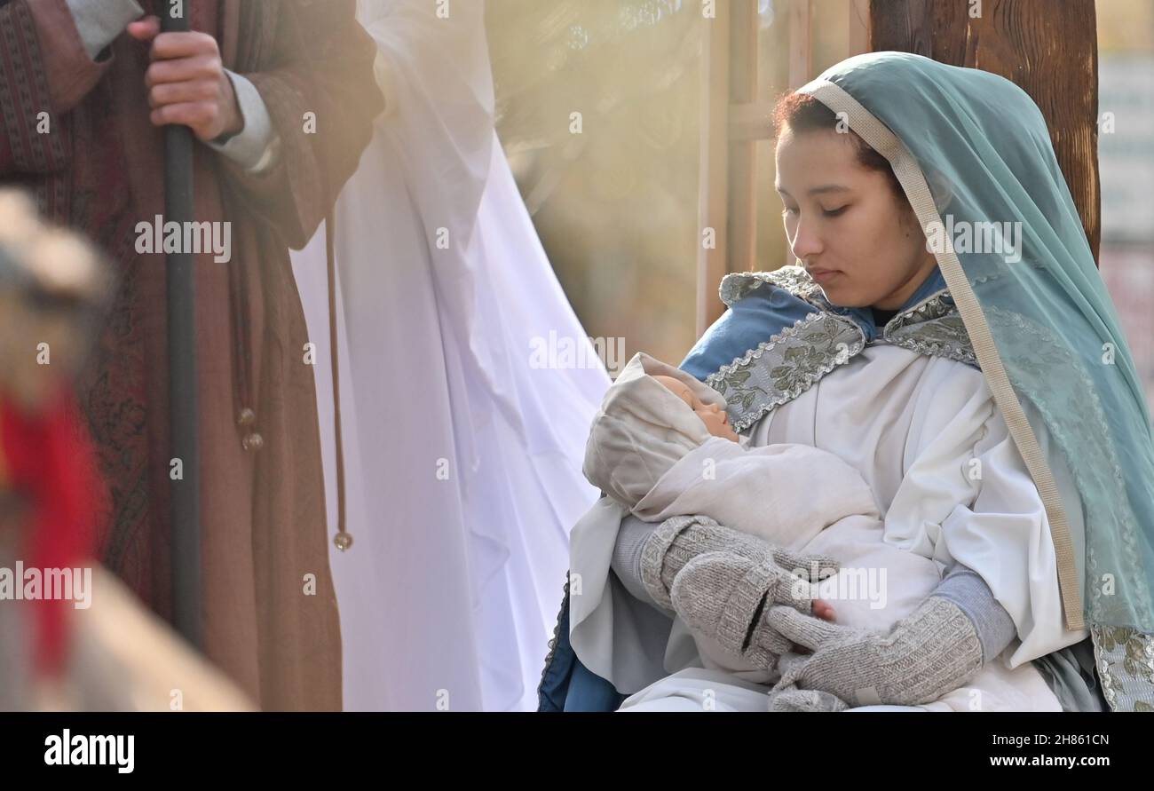 A girl portrays the The Virgin Mary holding the baby Jesus during a ...
