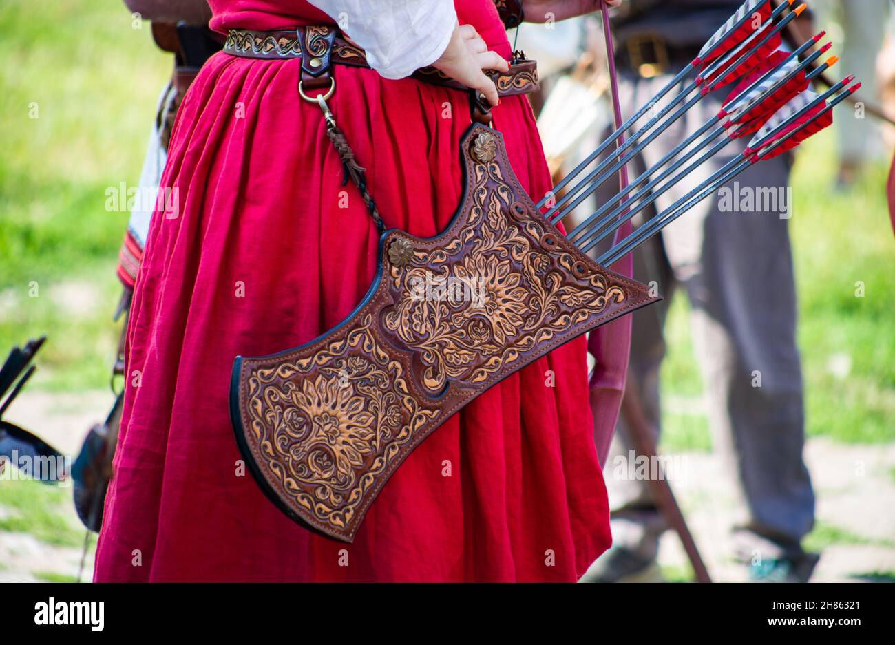 People in medieval clothes with bows on the territory of the castle ...