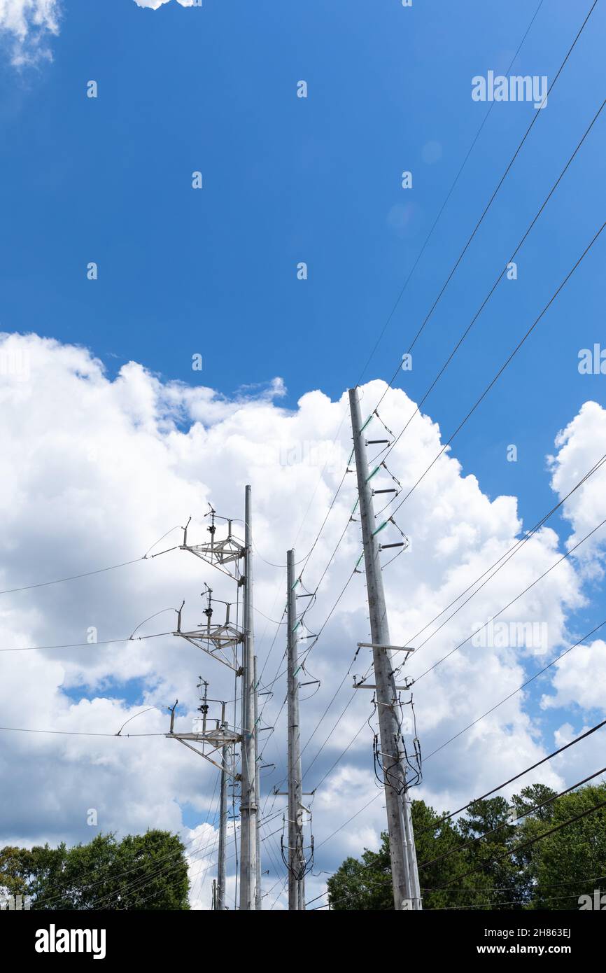 Tall metal electric power poles and cables against a blue sky with ...