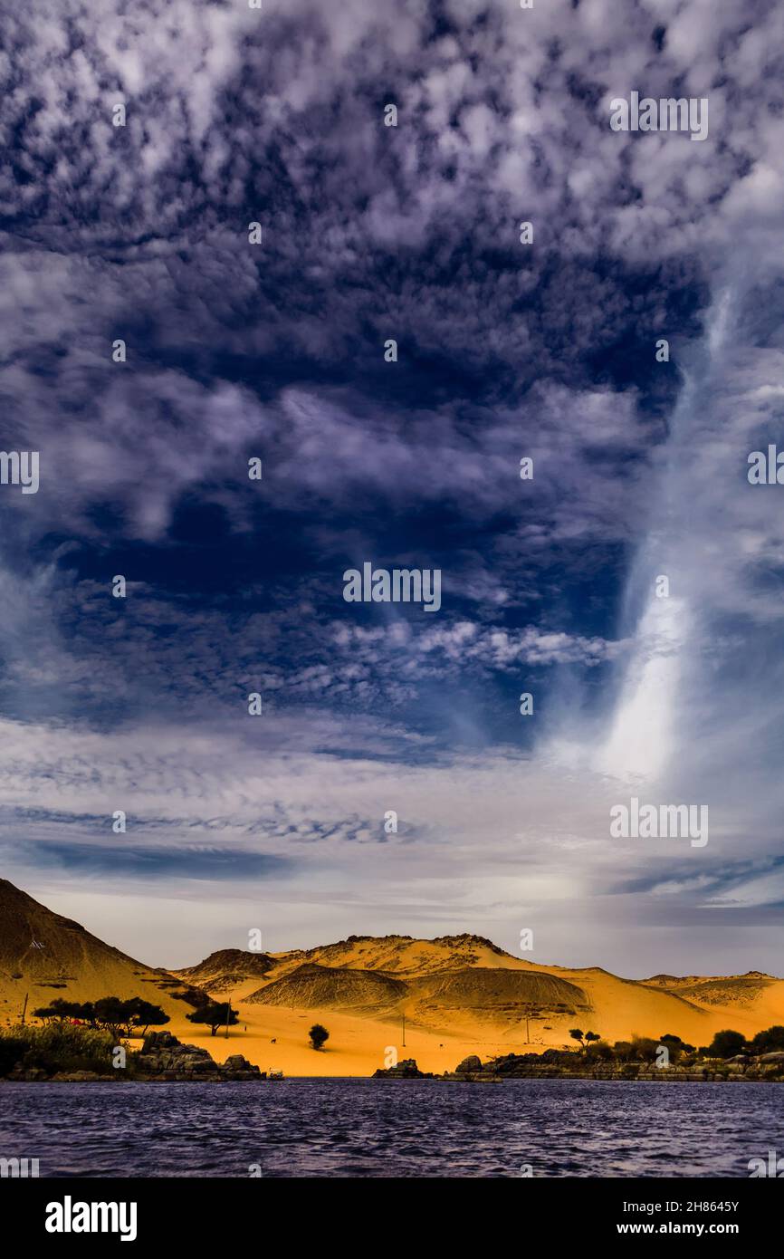 A vertical shot of Sand dunes with the sea under the beautiful sky in ...