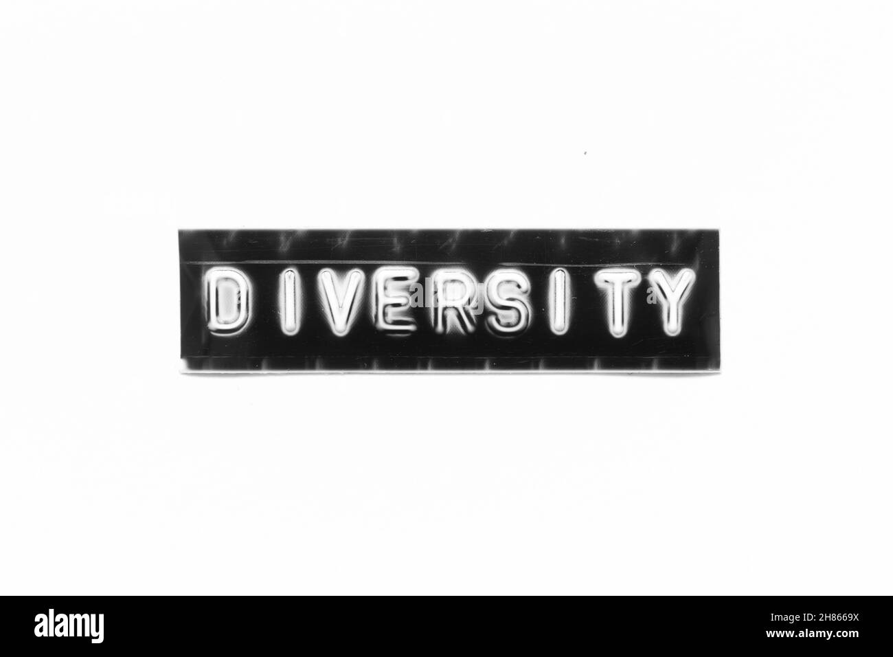 Embossed letter with word diversity in black banner on white paper ...