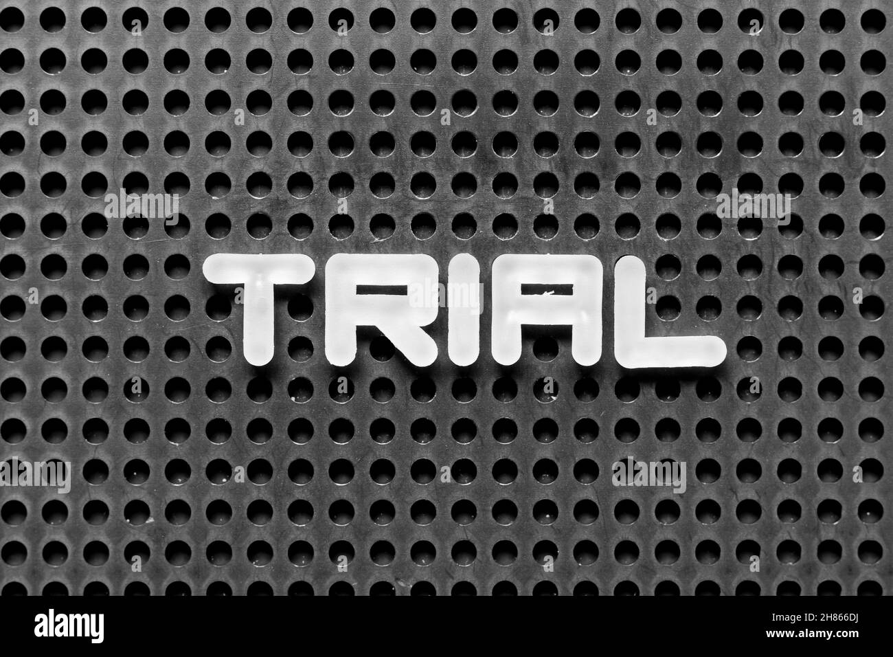 White alphabet letter in word trial on black pegboard background Stock ...
