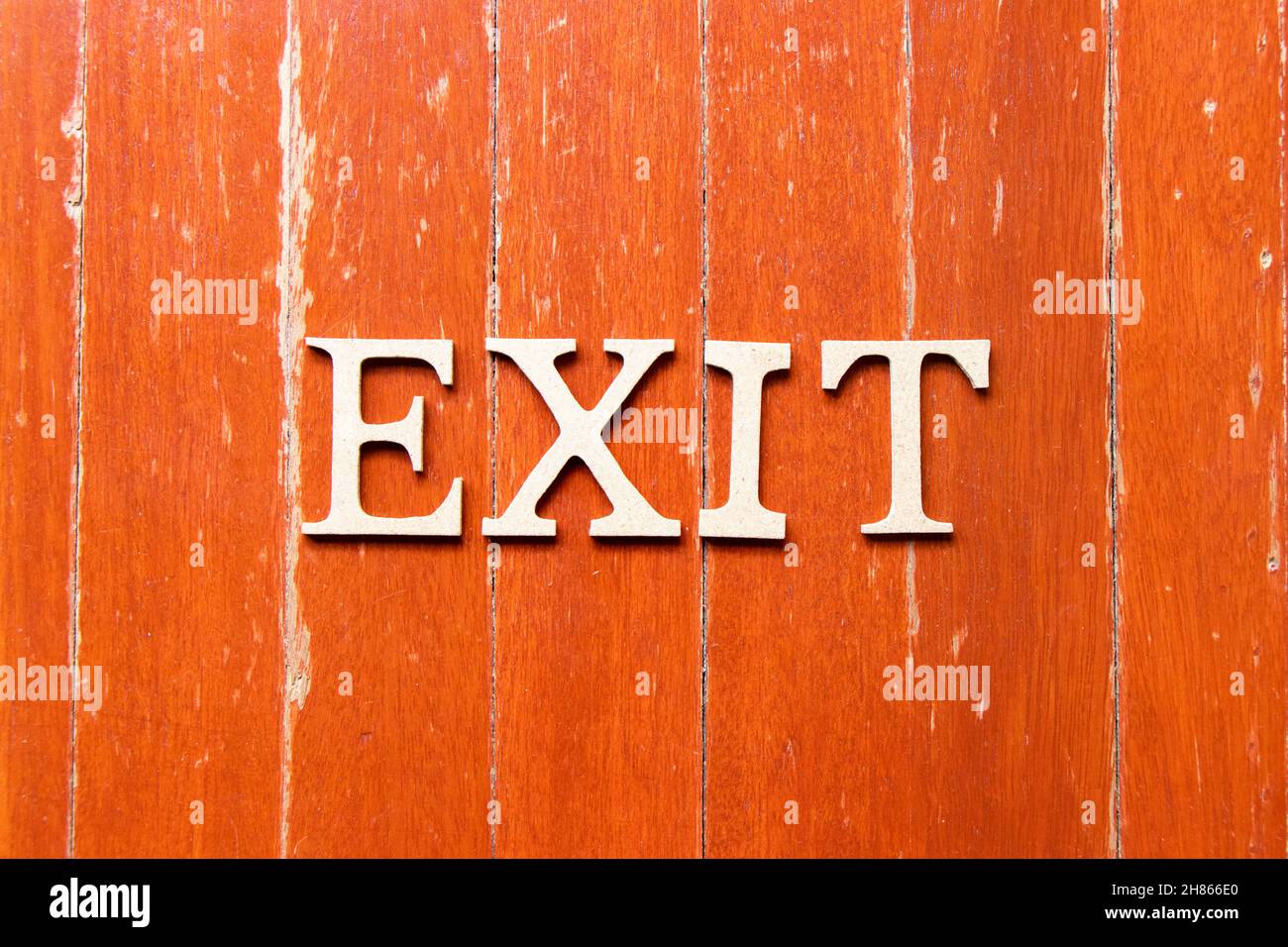 Alphabet letter in word exit on old red color wood plate background ...
