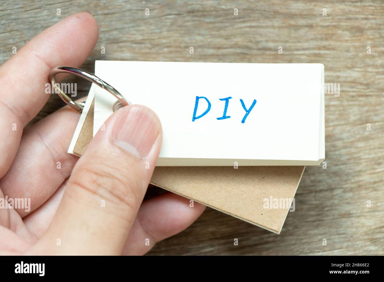 Man hold the flash card with handwriting word DIY (abbreviation of do ...