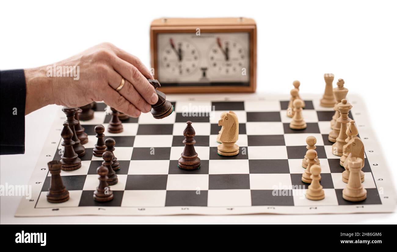 chess board with clock and figures on white background, selective focus ...