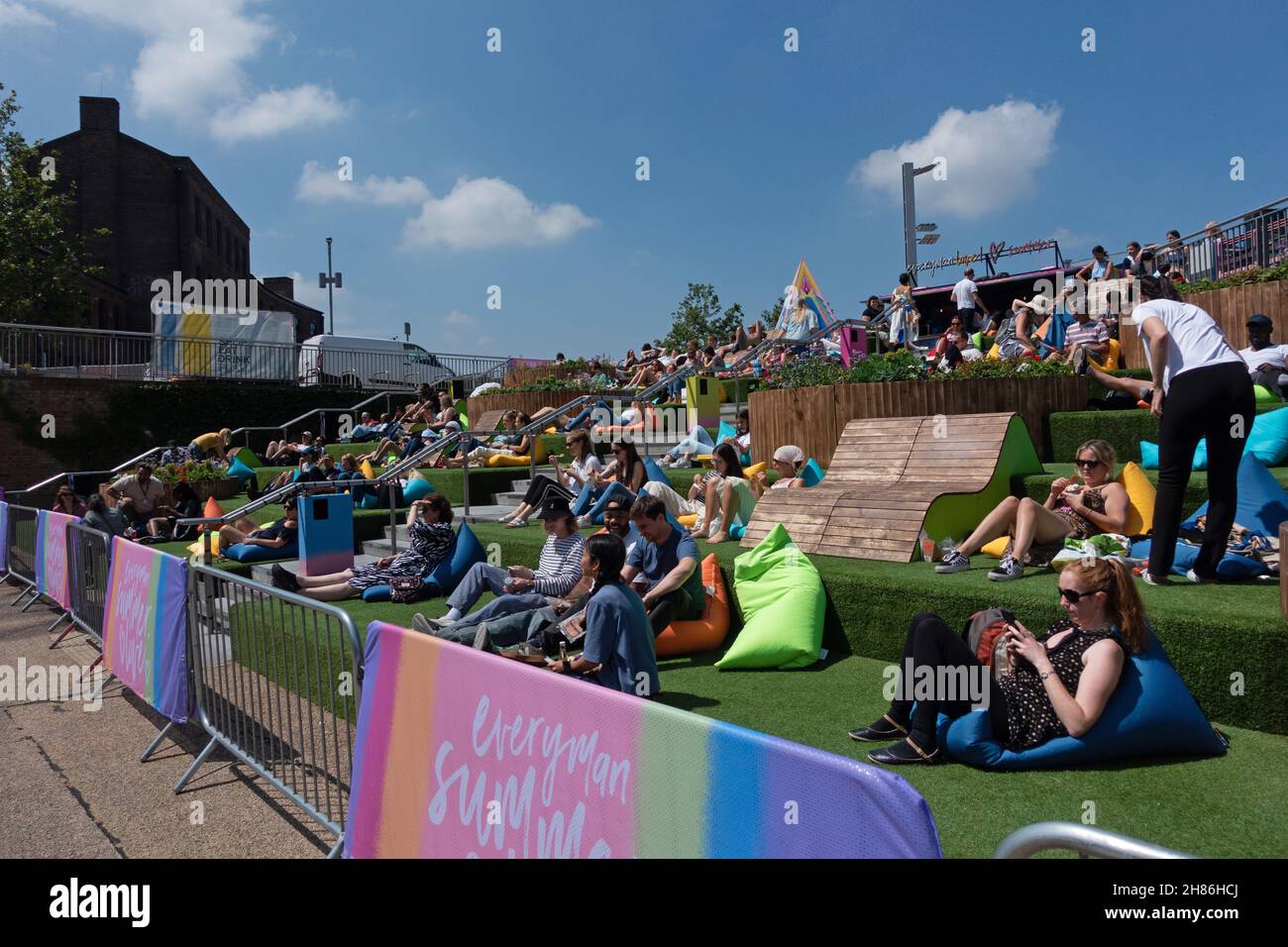 Crowds on Canalside Green Steps, kings cross, london, opposite the Wide ...