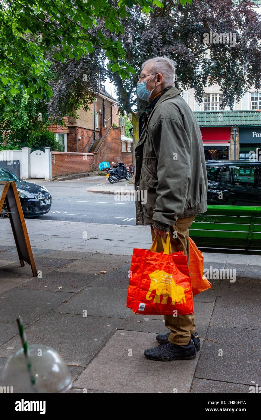 Elderly man with long life shopping bag with elephant motif hi-res ...