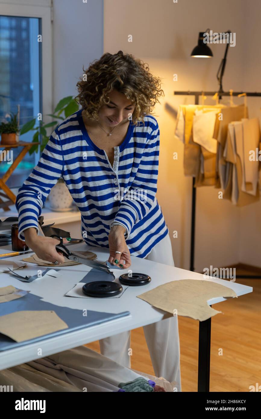 Woman tailor cut clothing samples of pattern drafts paper in garment ...