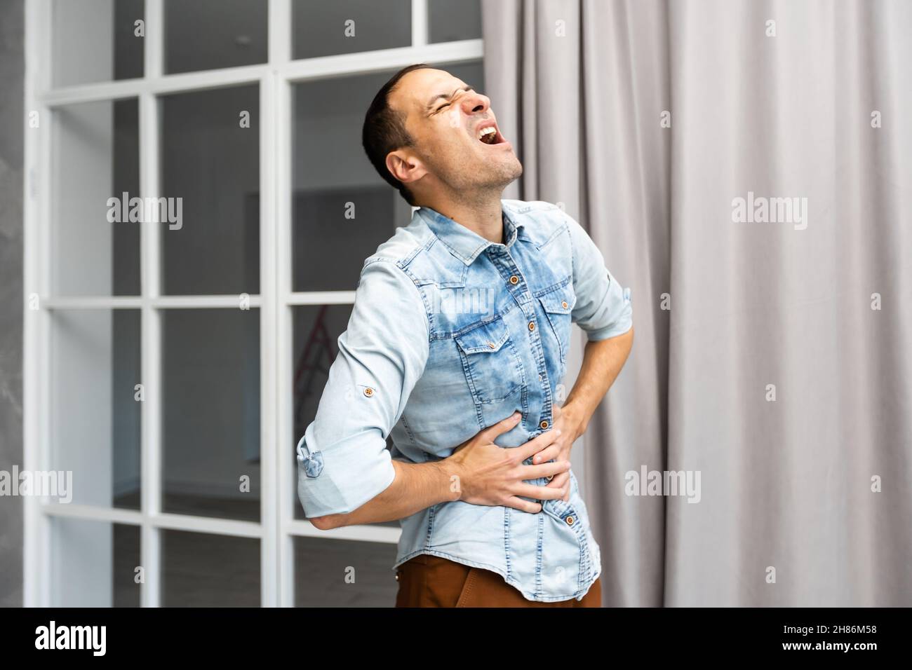 A man holding his stomach because he has diarrhea Stock Photo - Alamy