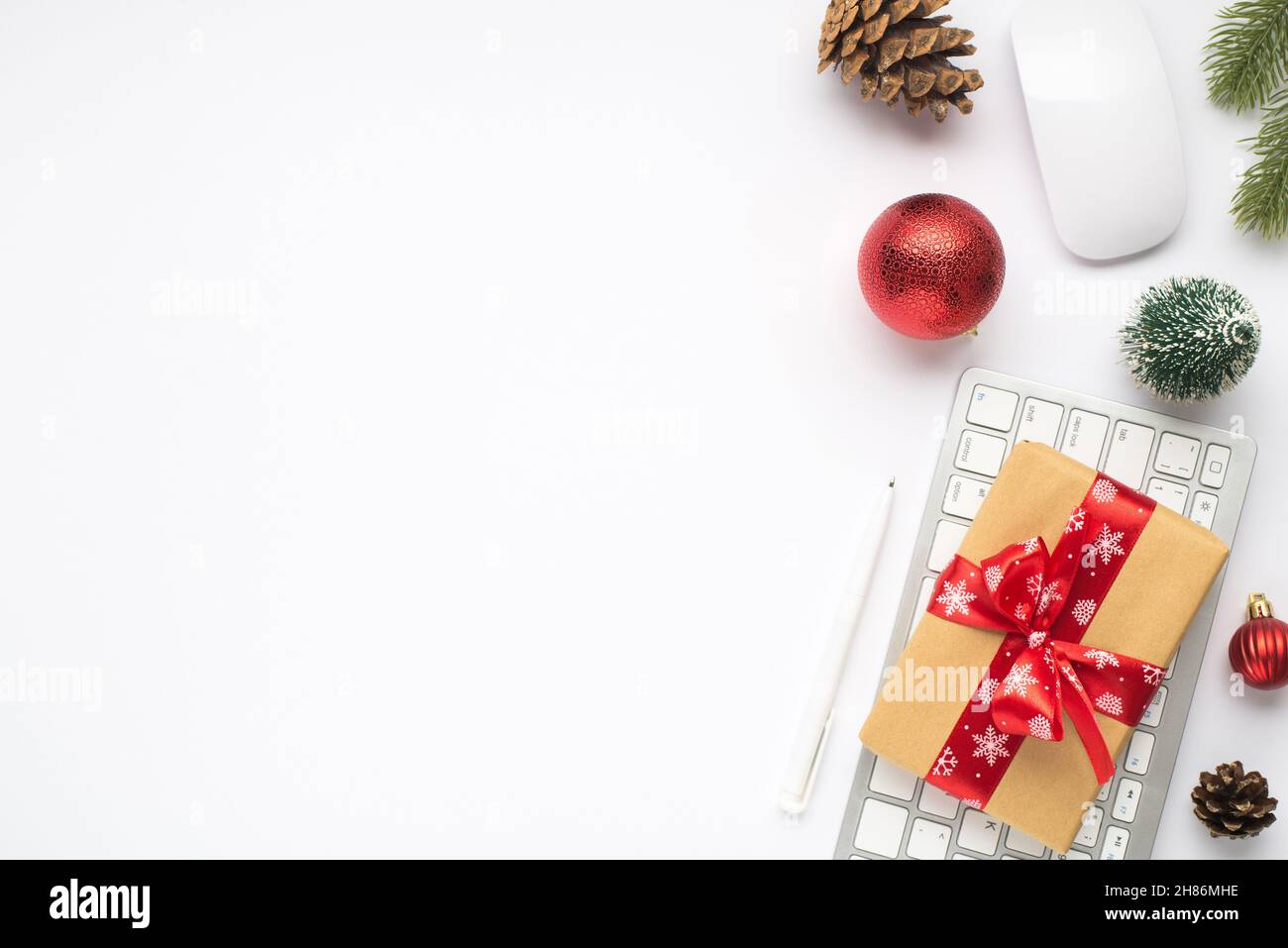 Top view photo of gift box with red bow on keyboard computer mouse pen ...