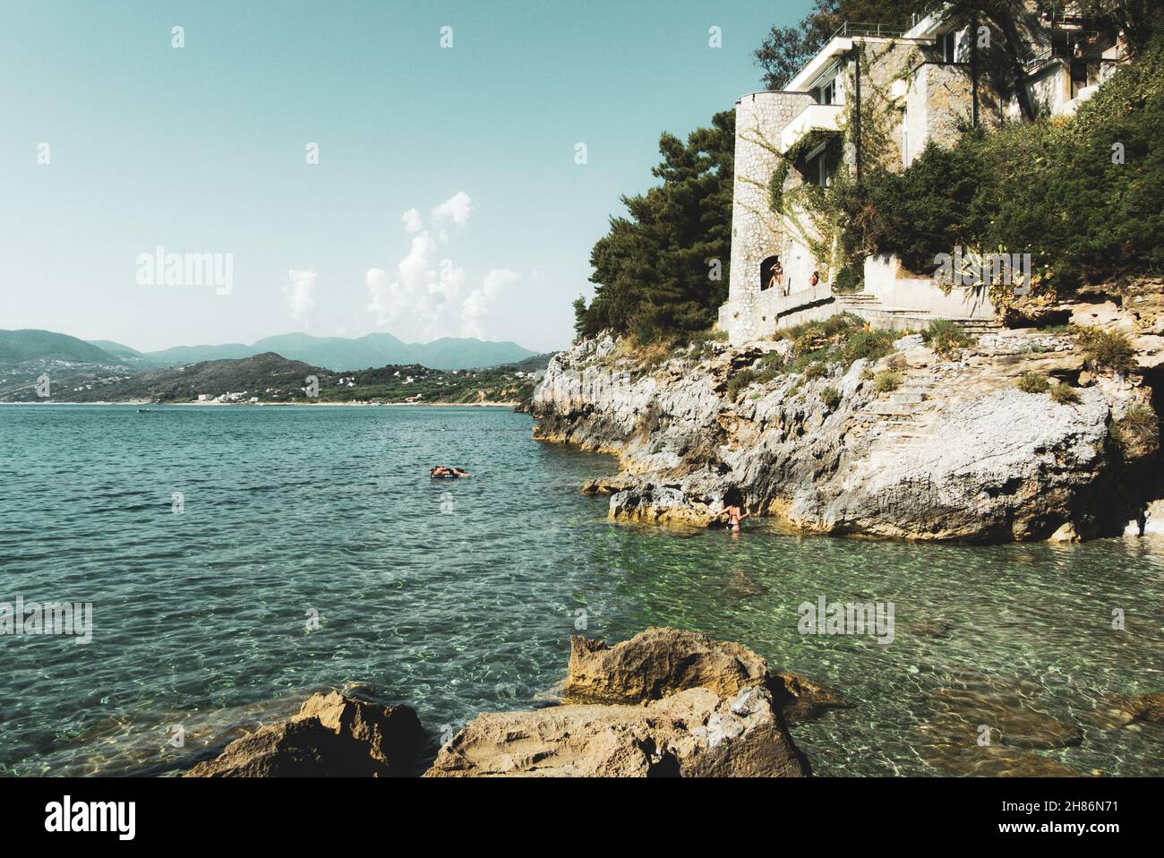 A beautiful scenery of rocky cliffs on blue water against a light sky ...