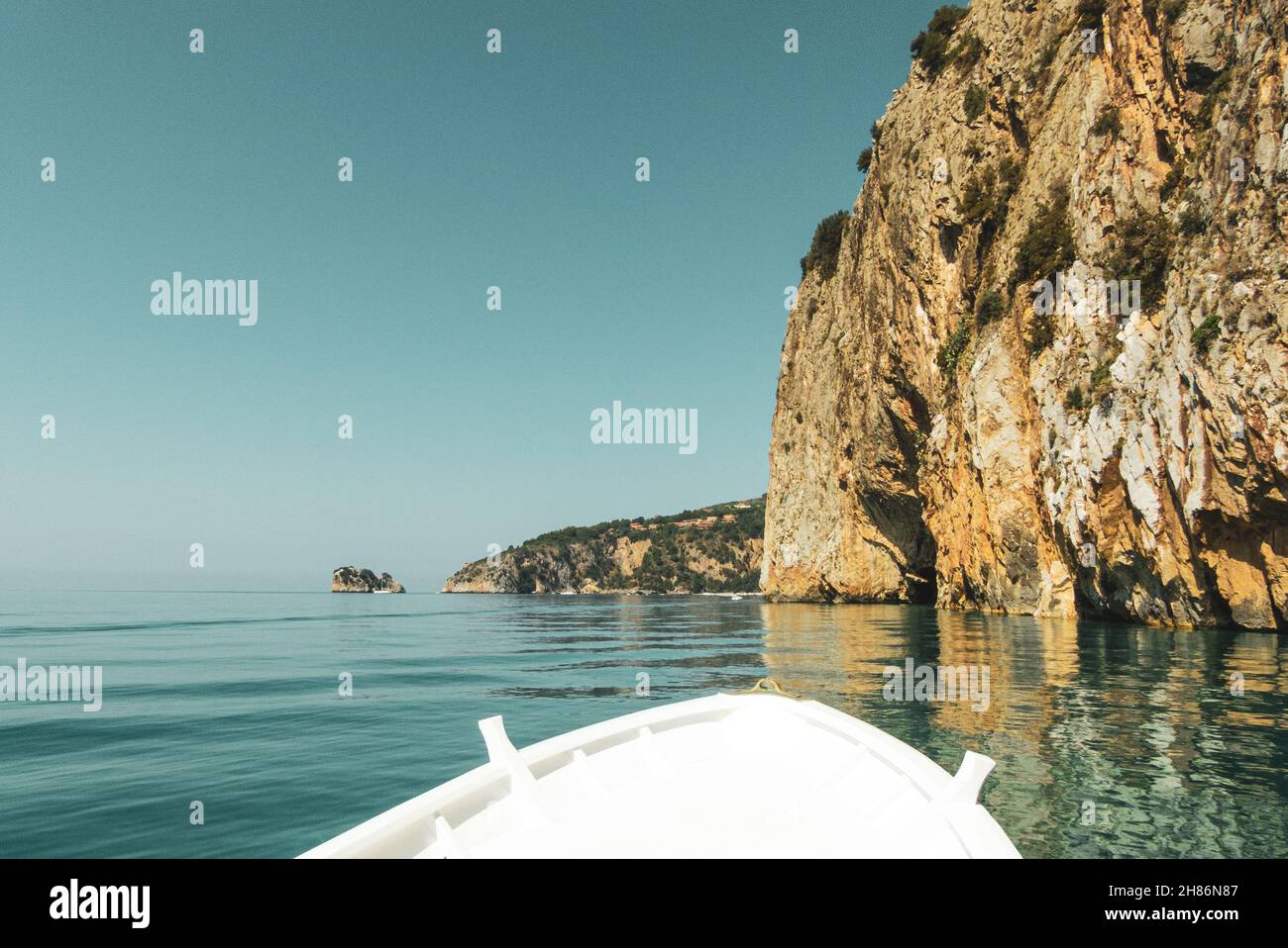 A beautiful scenery of rocky cliffs on blue water against a light sky ...
