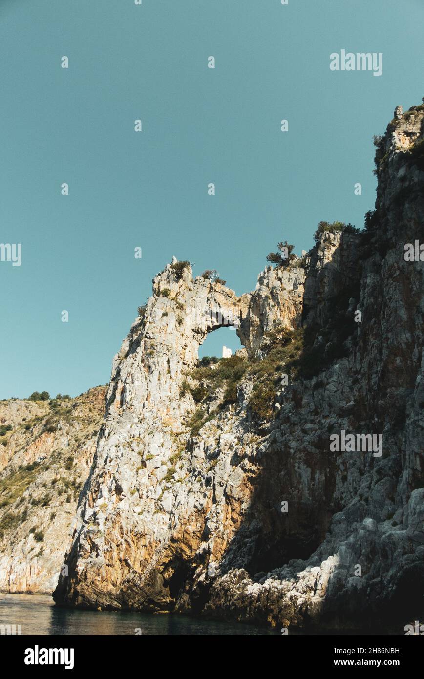 A beautiful scenery of rocky cliffs on blue water against a light sky ...