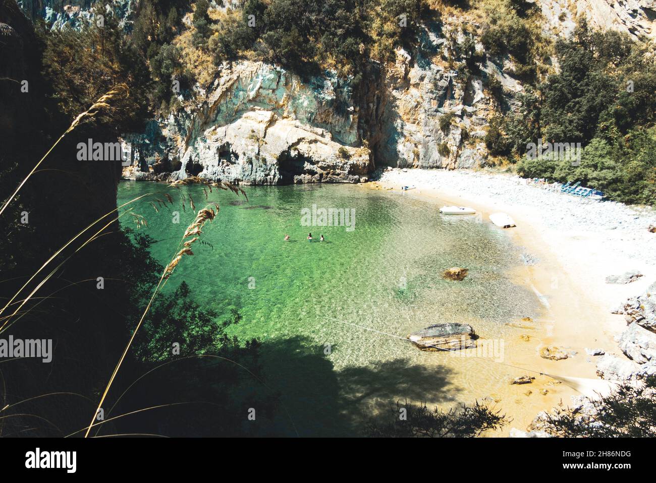 A beautiful aerial view of blue sunny water under rocky cliffs on a ...