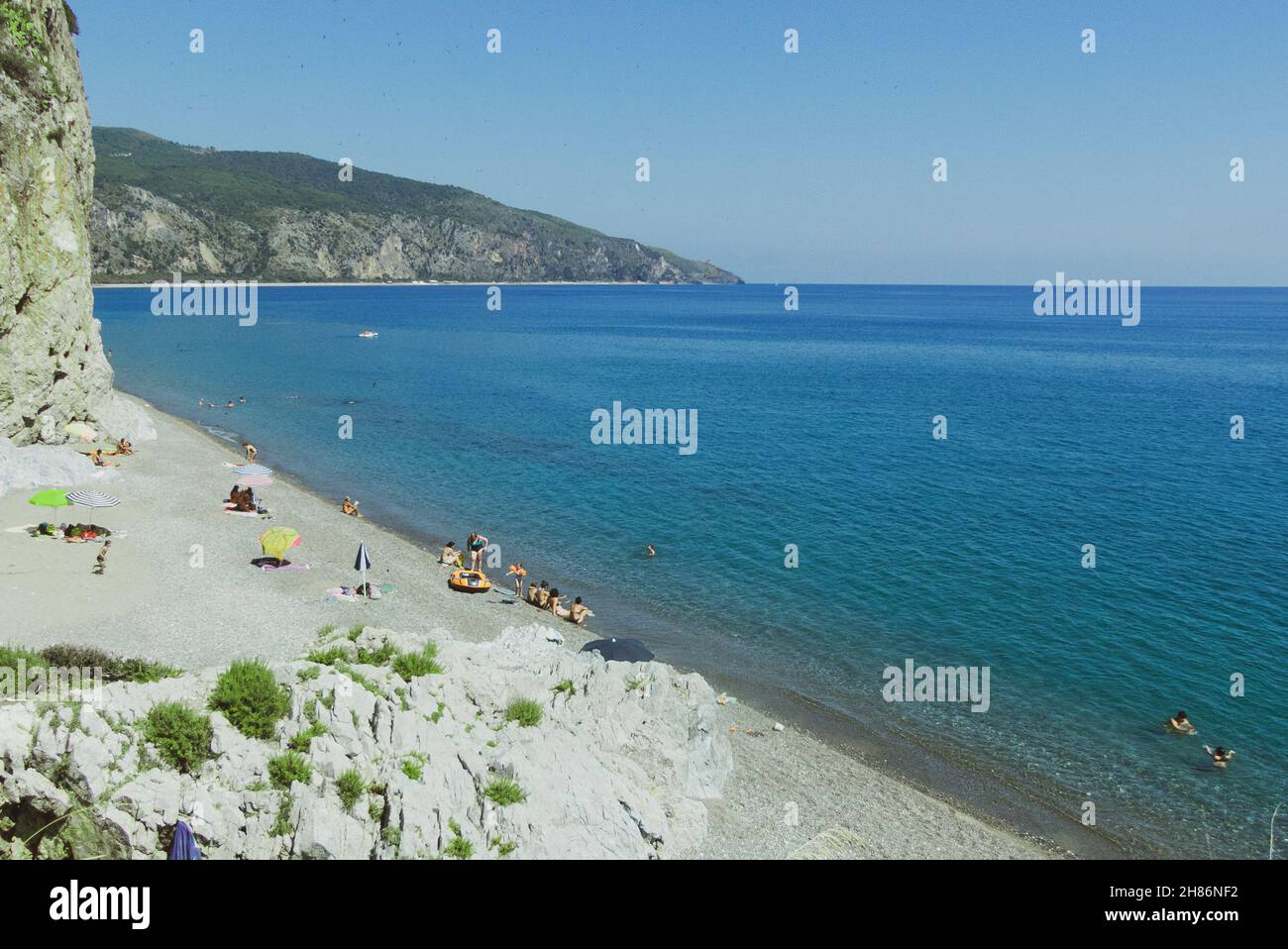 A beautiful scenery of blue water and rocky mountains under a sunny sky ...