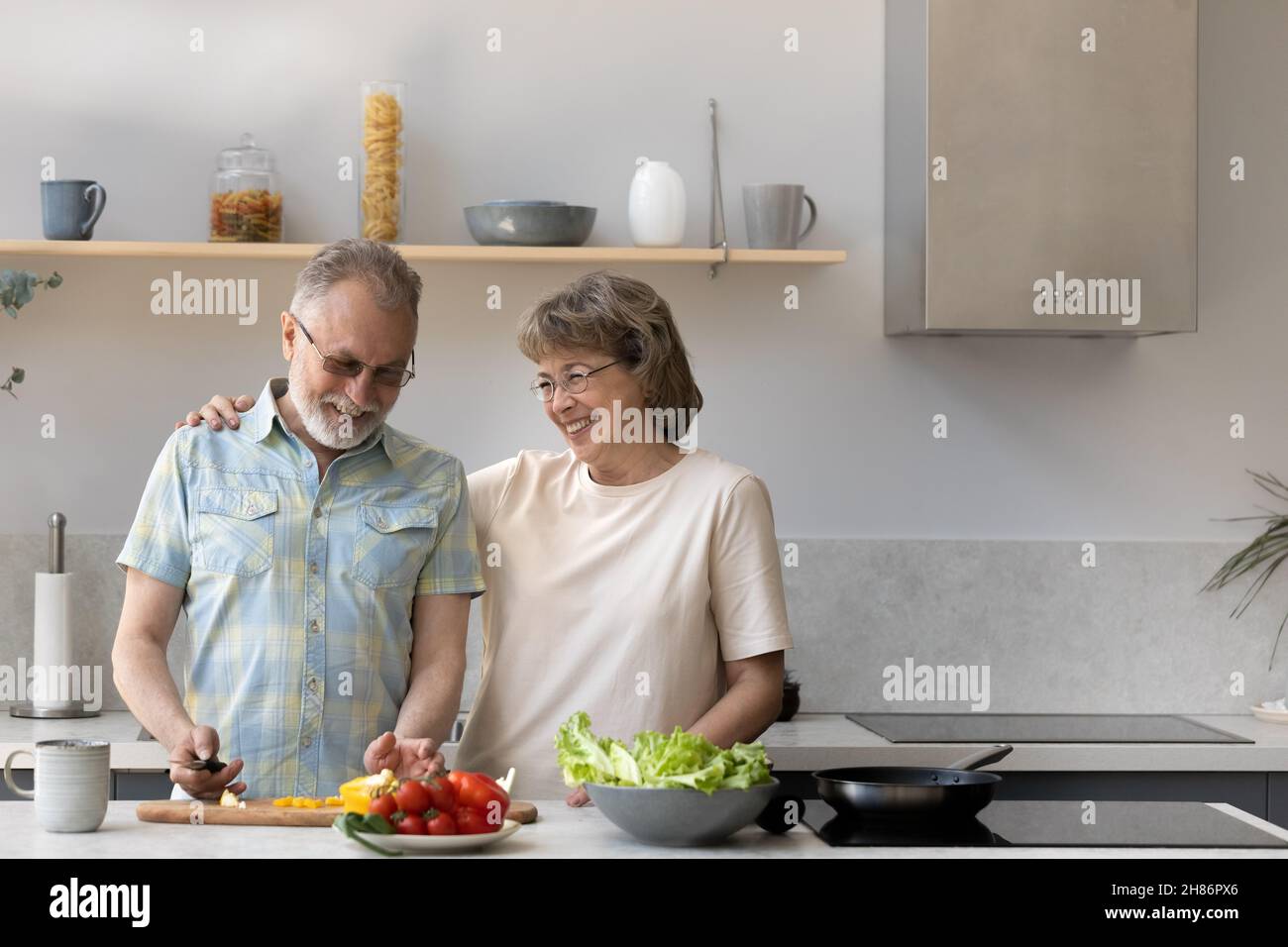 Happy joyful older husband and wife sharing cooking chores Stock Photo ...