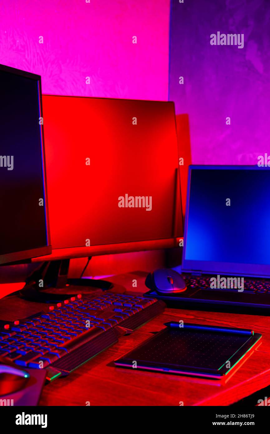 Graphic designer workplace in neon light. Computer equipment and ...