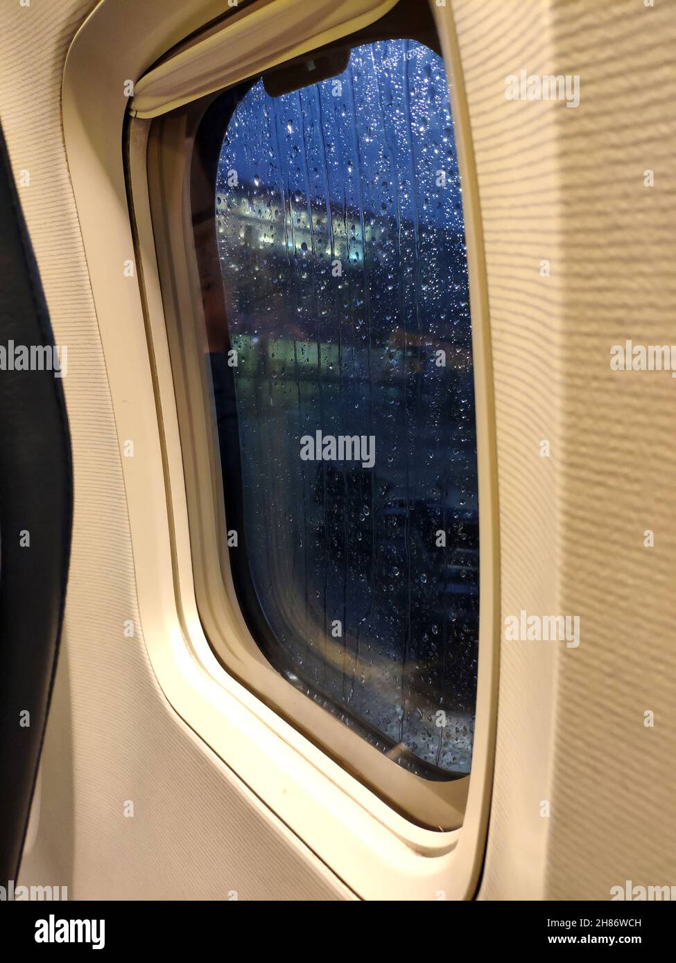 Airplane window close view. Rainy weather outside before take off Stock ...
