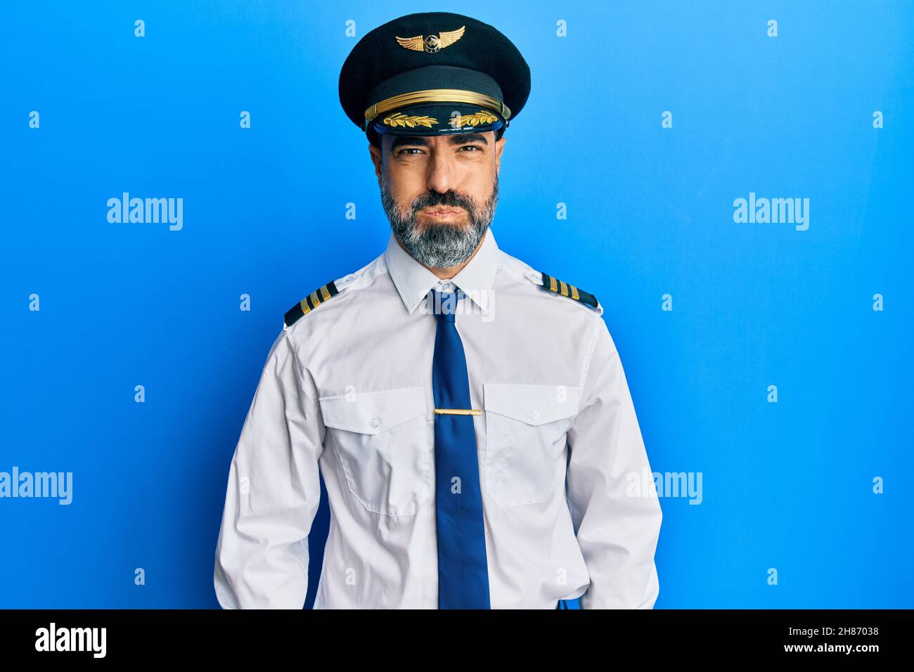 Middle age man with beard and grey hair wearing airplane pilot uniform ...