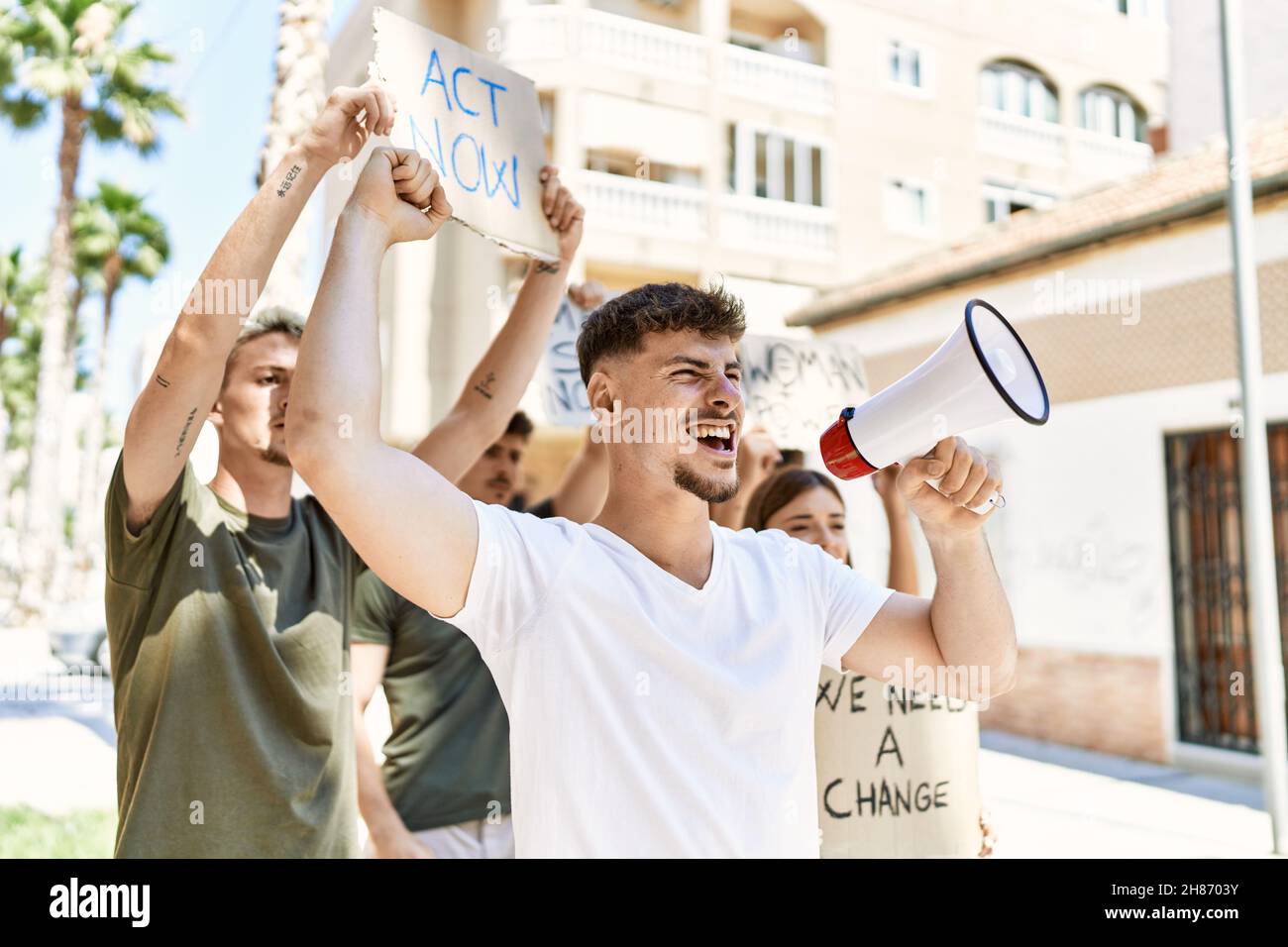Group of young hispanic activists protesting holding banner and using ...