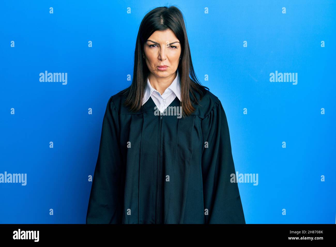 Young hispanic woman wearing judge uniform depressed and worry for ...