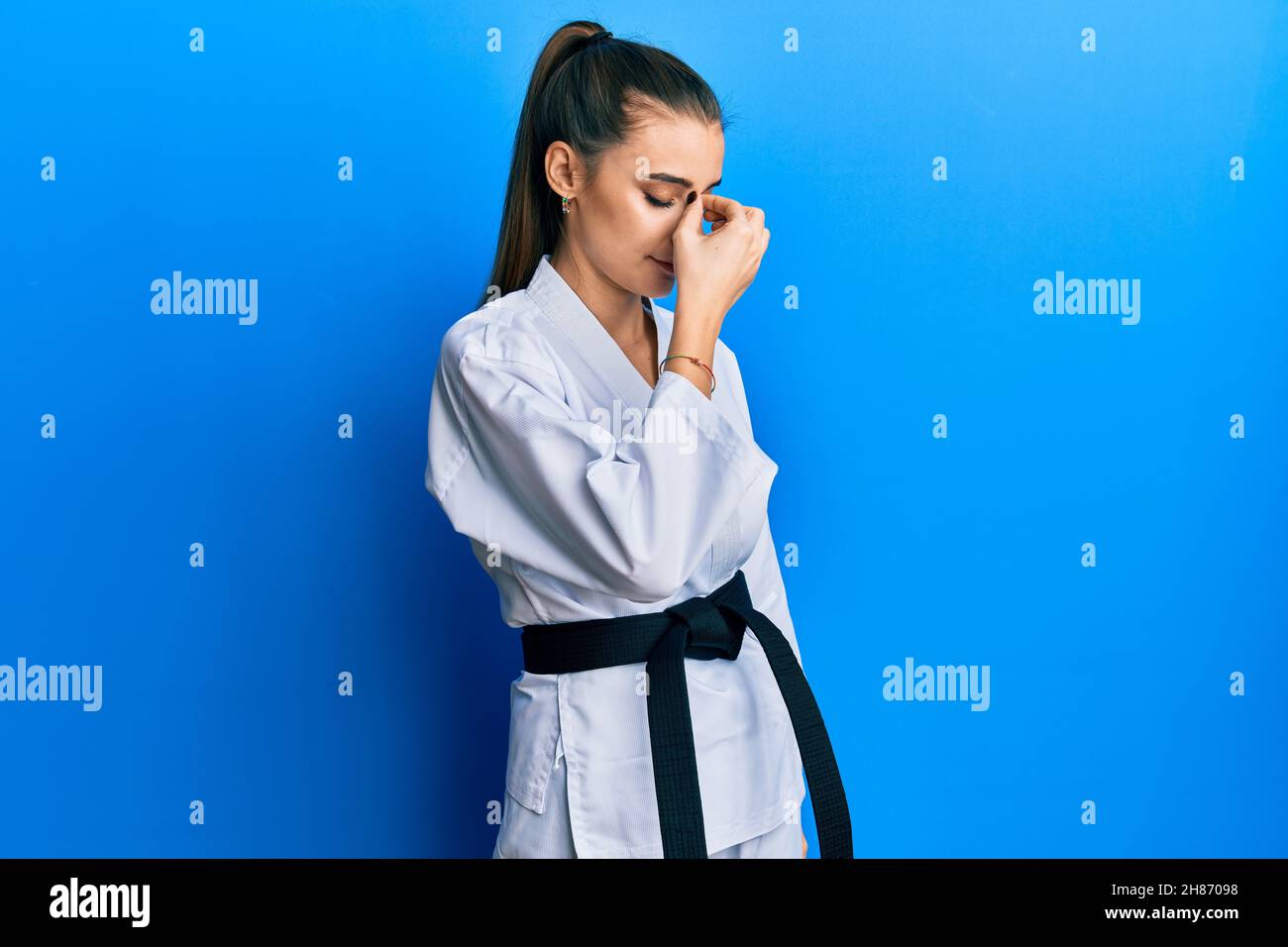Beautiful brunette young woman wearing karate fighter uniform with ...