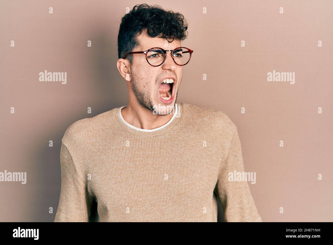 Young hispanic man wearing casual clothes and glasses angry and mad ...