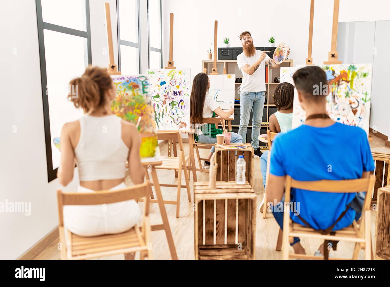 Group of people smiling happy drawing in paint class at art studio ...