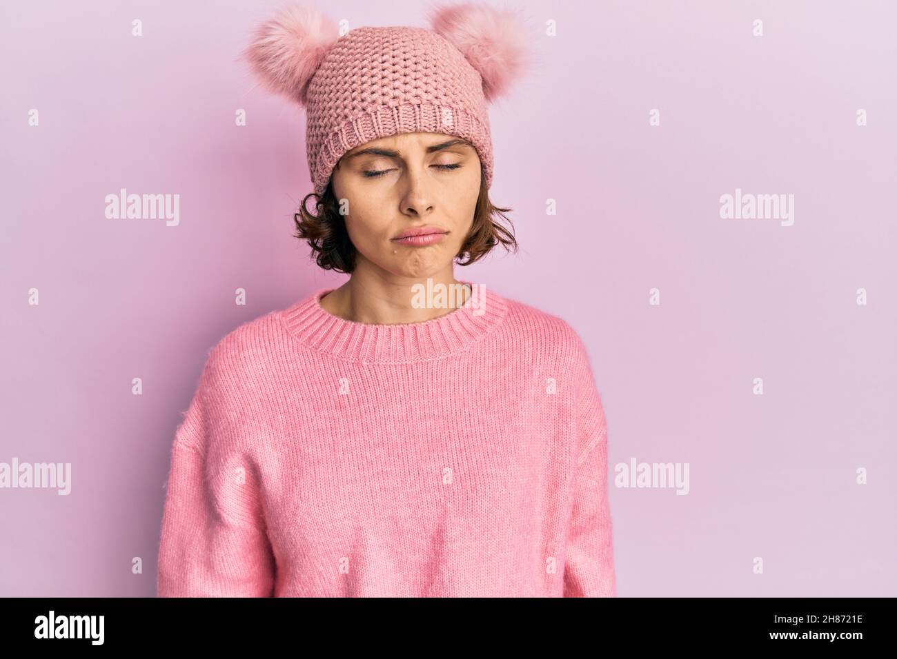 Young brunette woman wearing cute wool cap depressed and worry for ...