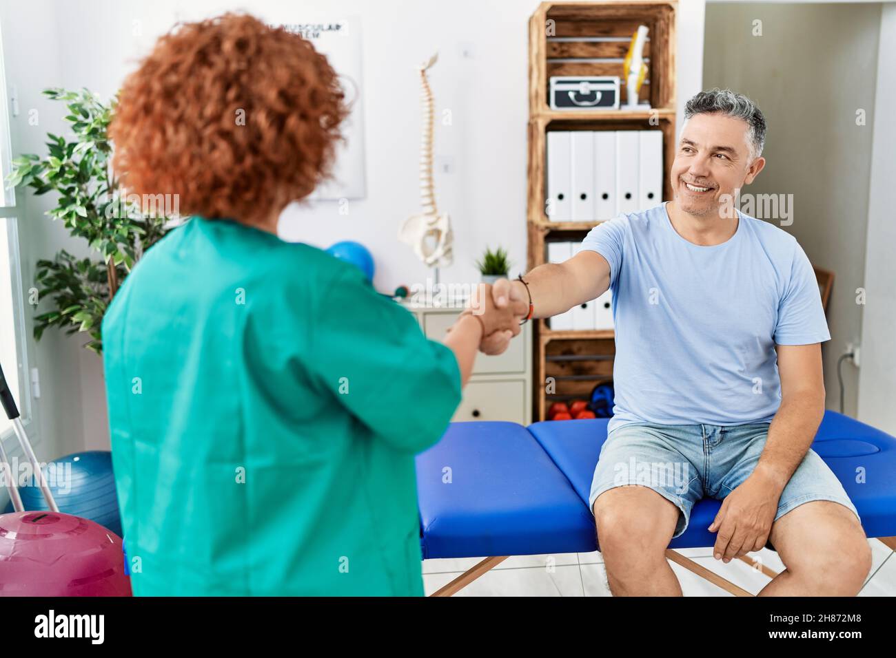 Middle age man and woman wearing physiotherapy uniform having rehab ...