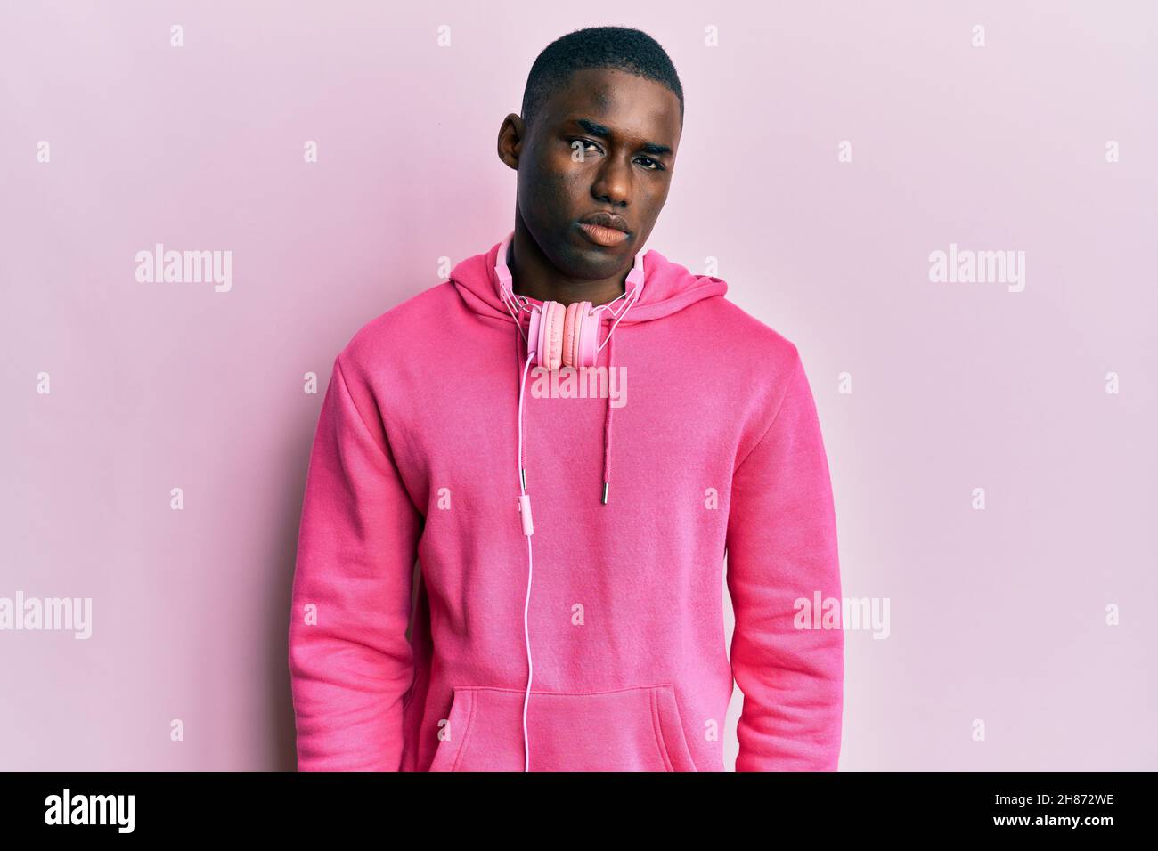 Young african american man wearing gym clothes and using headphones ...