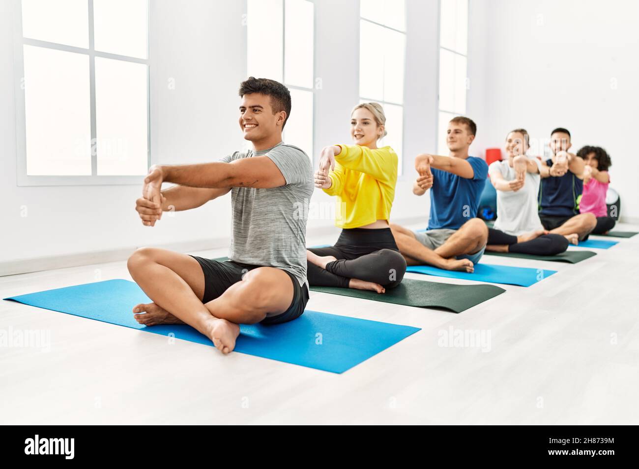 Group of young people smiling happy stretching at sport center Stock ...