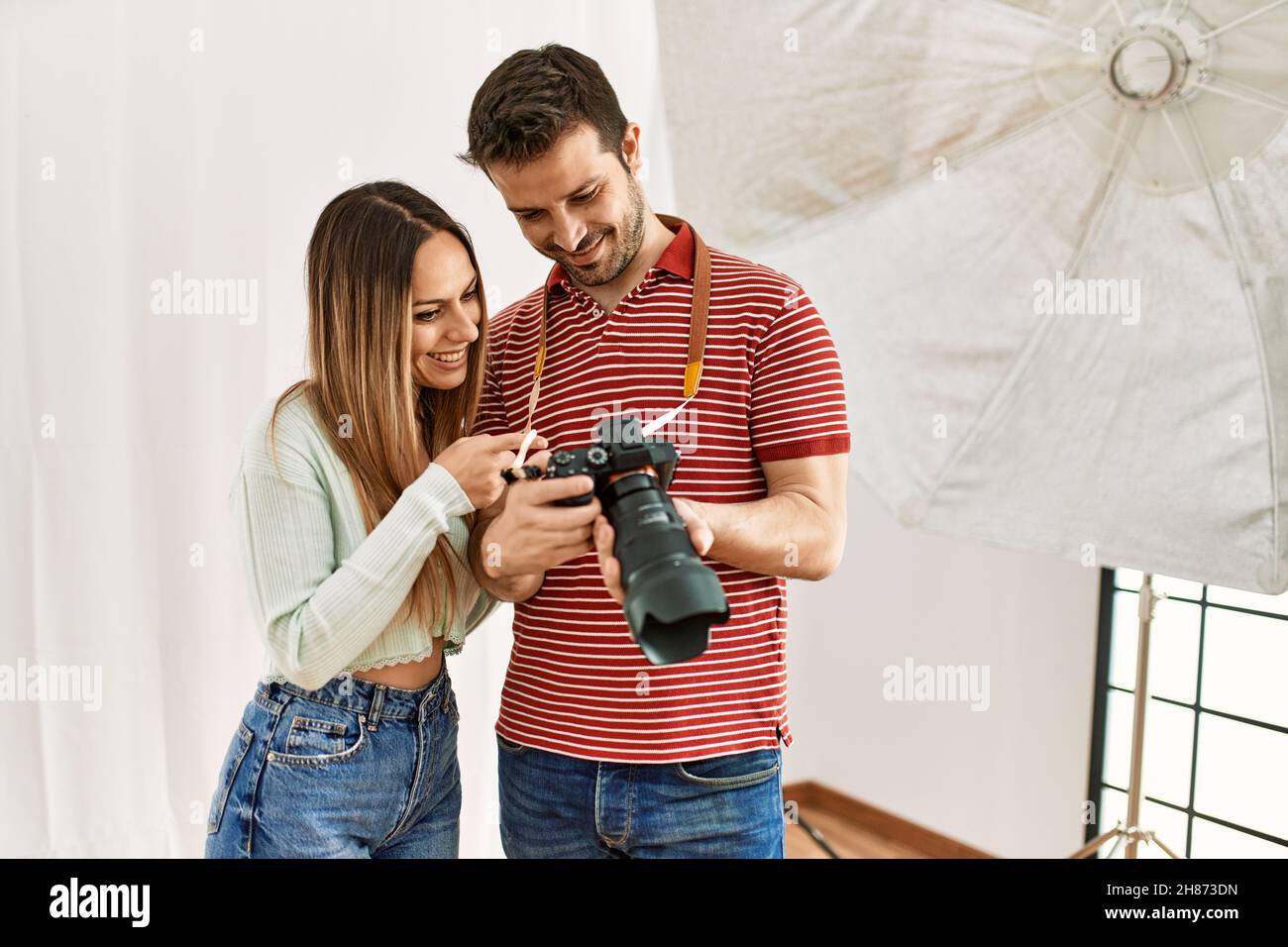 Professional photographer showing camera photos to model at photography ...