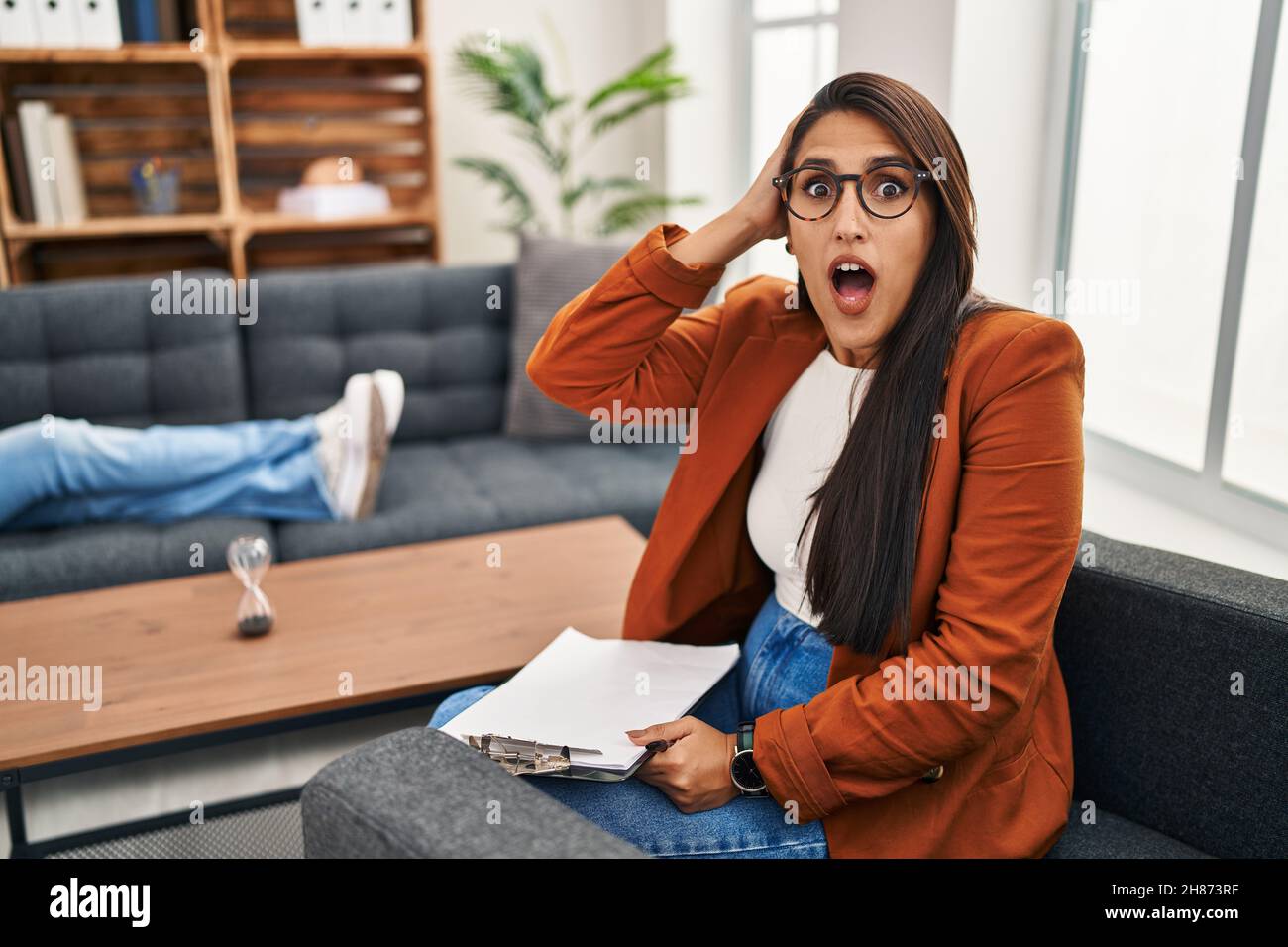 Young hispanic woman working as psychology counselor crazy and scared ...