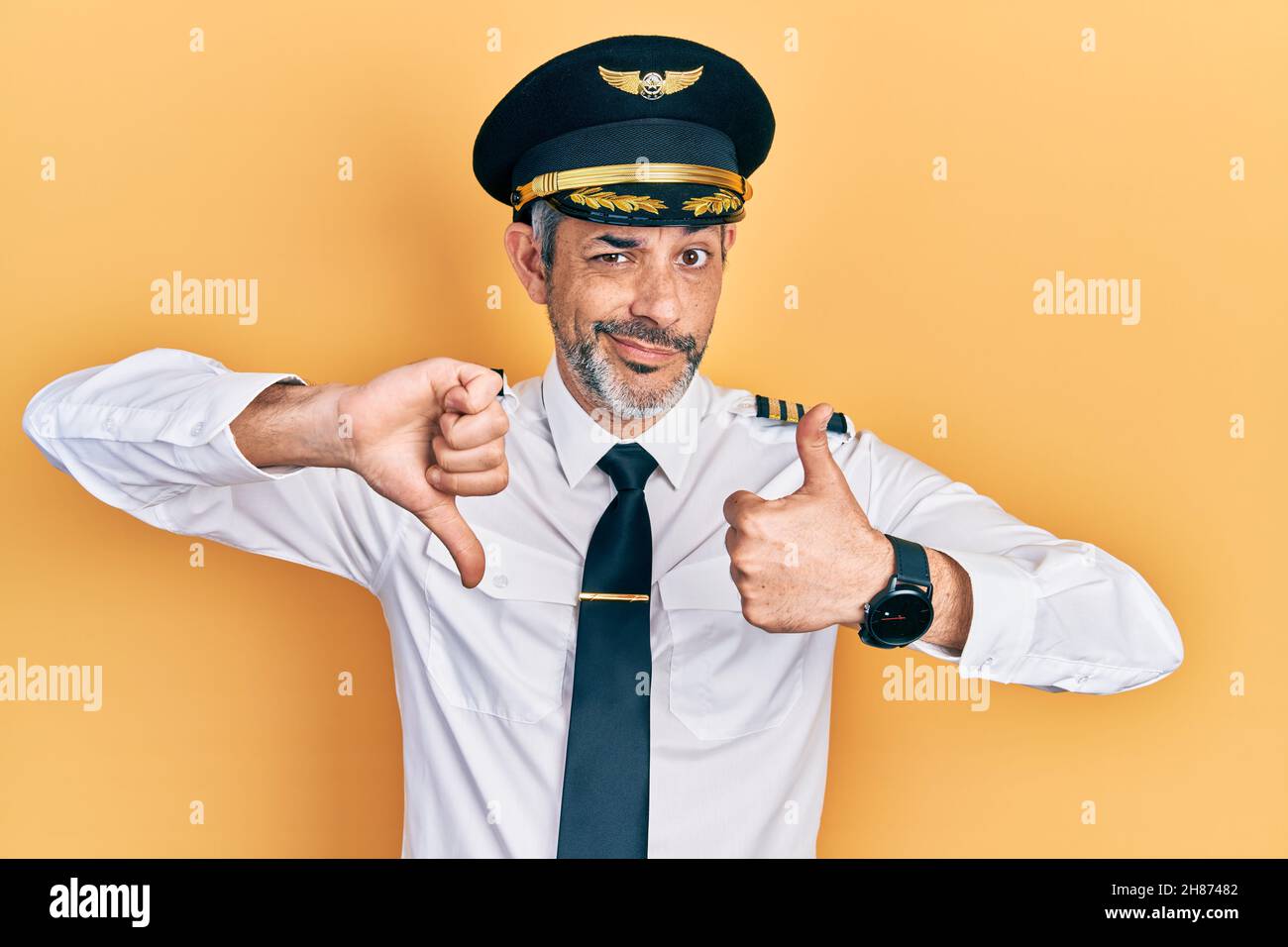Handsome middle age man with grey hair wearing airplane pilot uniform ...