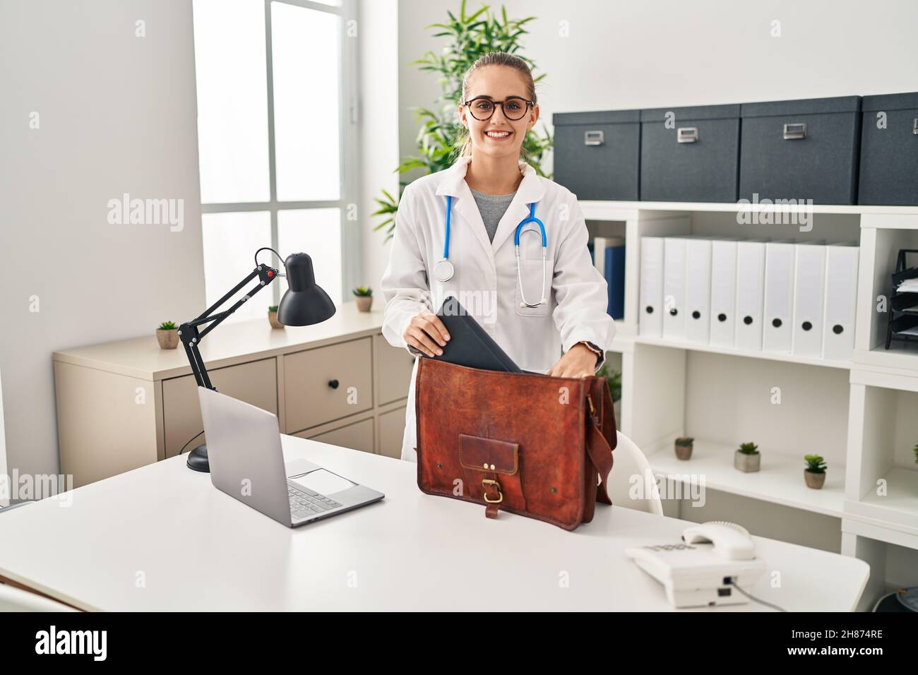 Young doctor woman at the clinic smiling with a happy and cool smile on ...