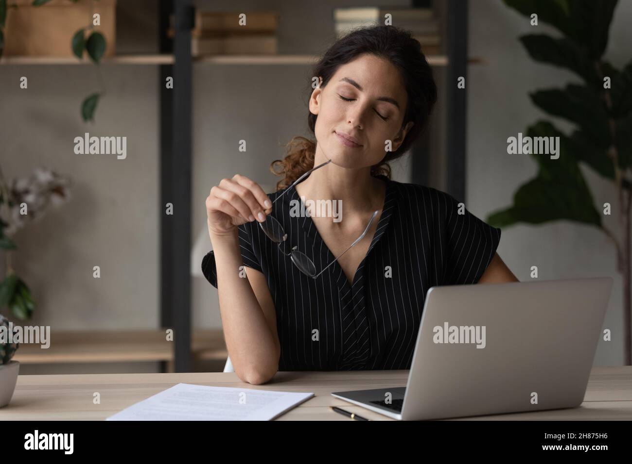 Young latina woman close eyes take break from computer work Stock Photo ...