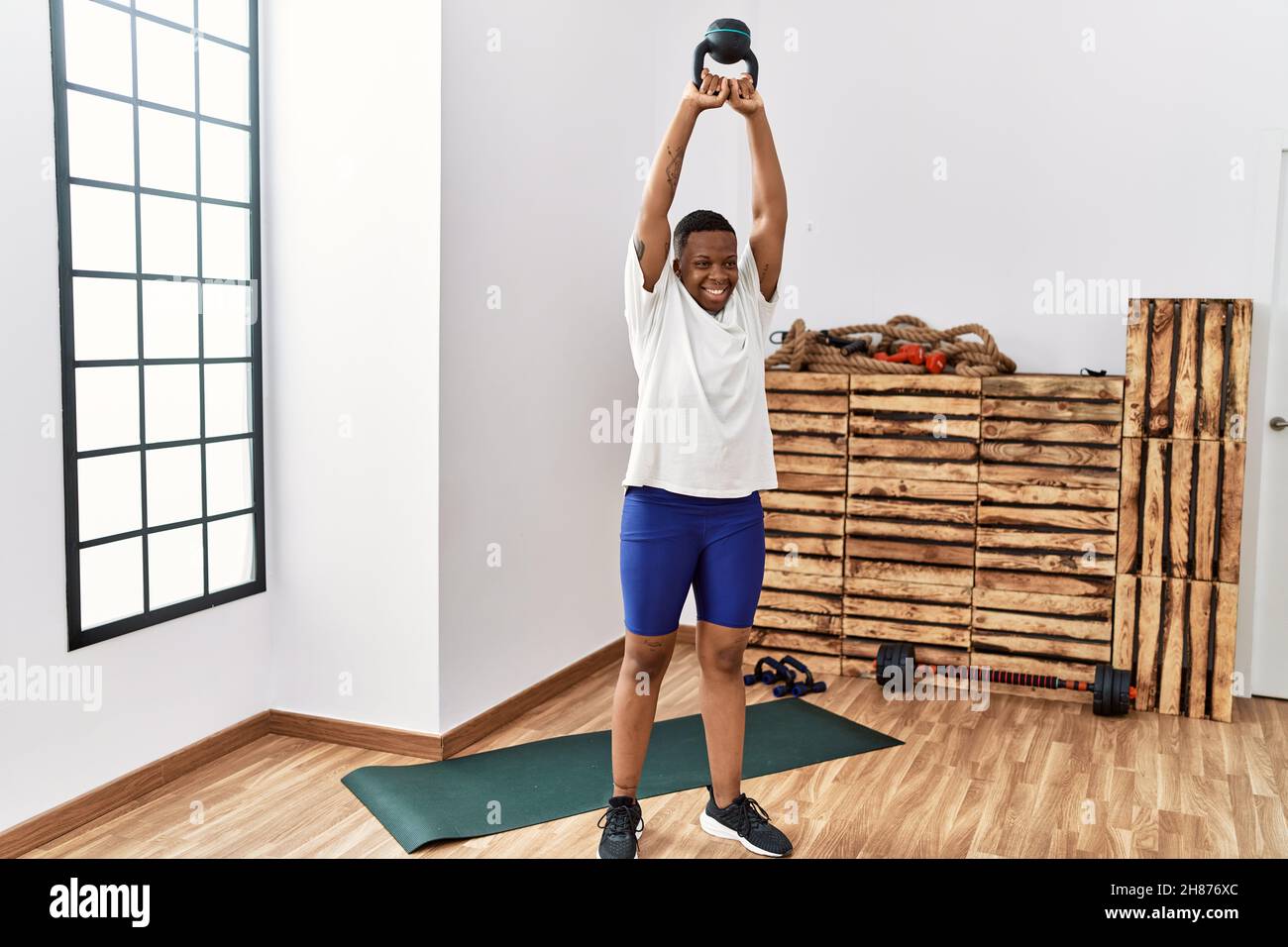 Young african man training with dumbbells at the gym Stock Photo - Alamy