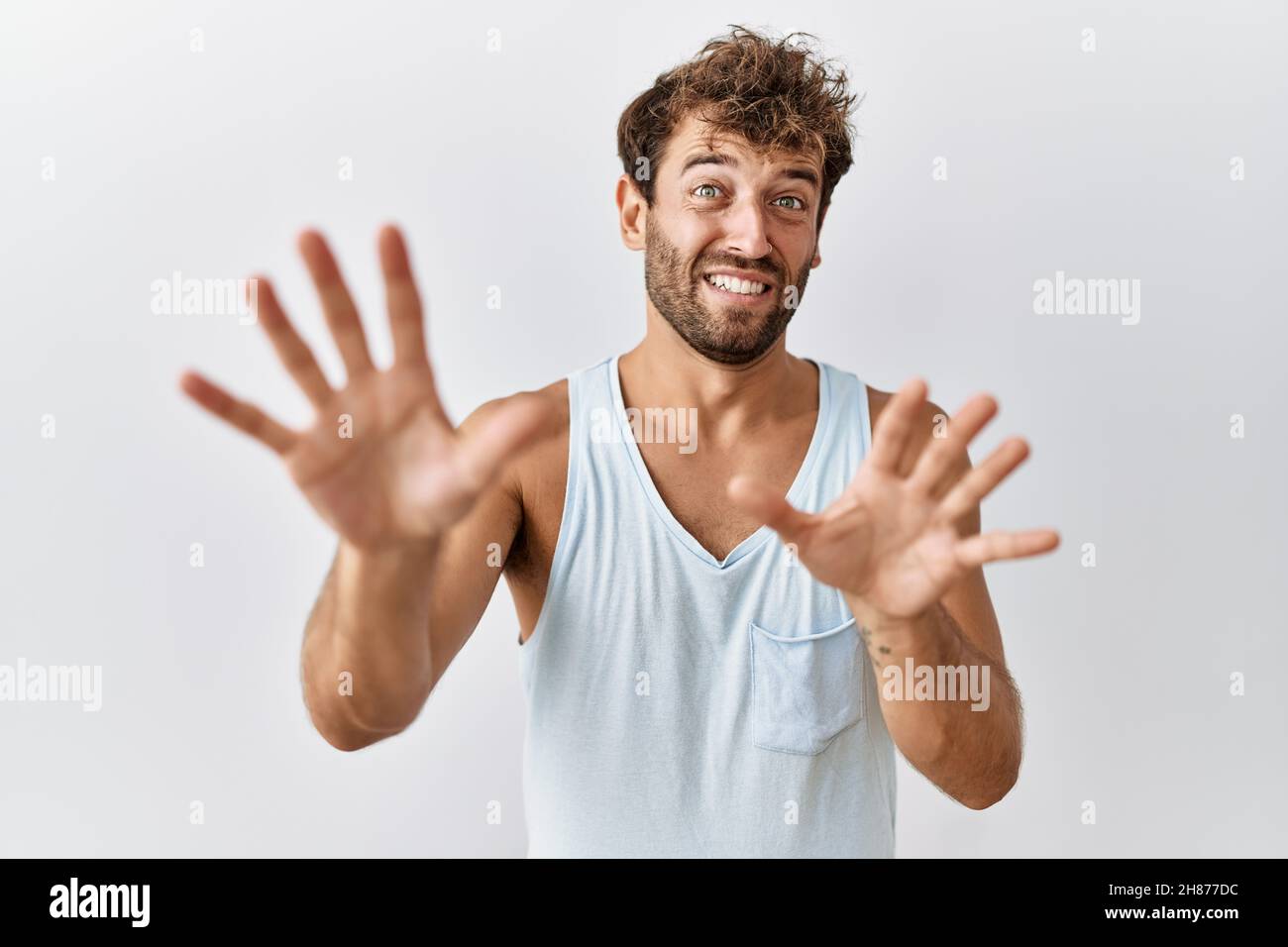 Young handsome man standing over isolated background afraid and ...