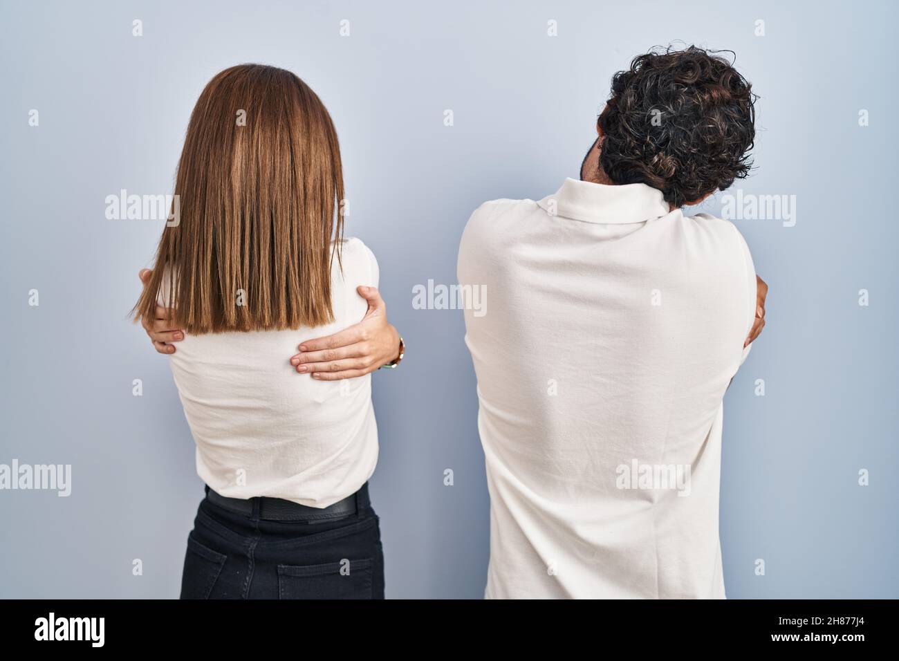 Young couple wearing casual clothes standing together hugging oneself ...