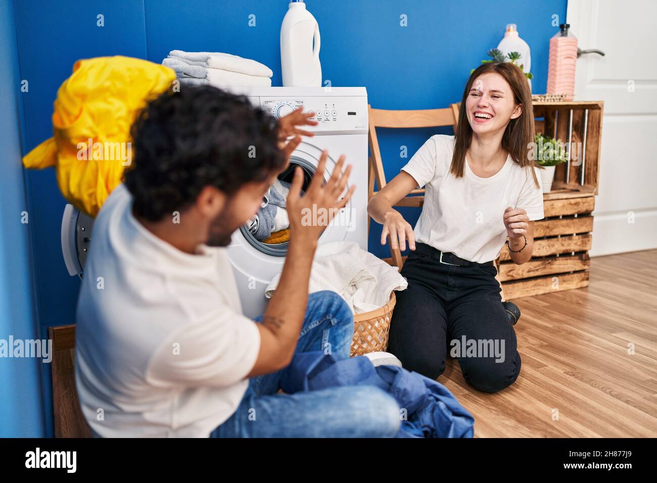 Man and woman couple smiling confident playing with cleaning clothes at ...