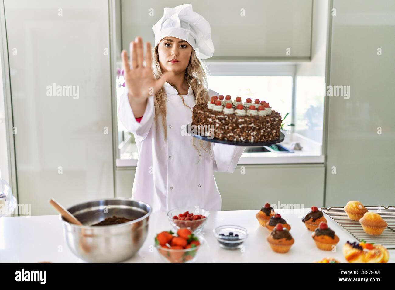 Young caucasian pastry chef woman cooking pastries and cake at the ...
