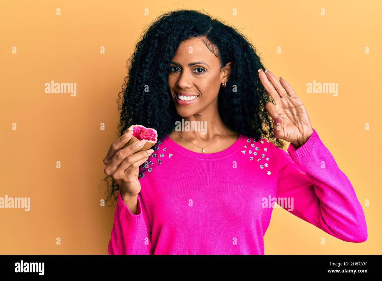 Middle age african american woman holding geode doing ok sign with ...