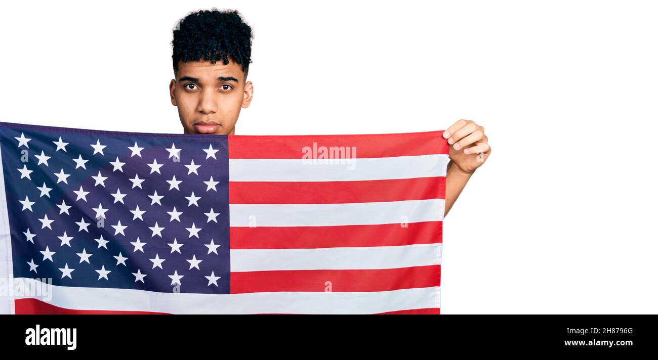 Young african american man holding united states flag depressed and ...