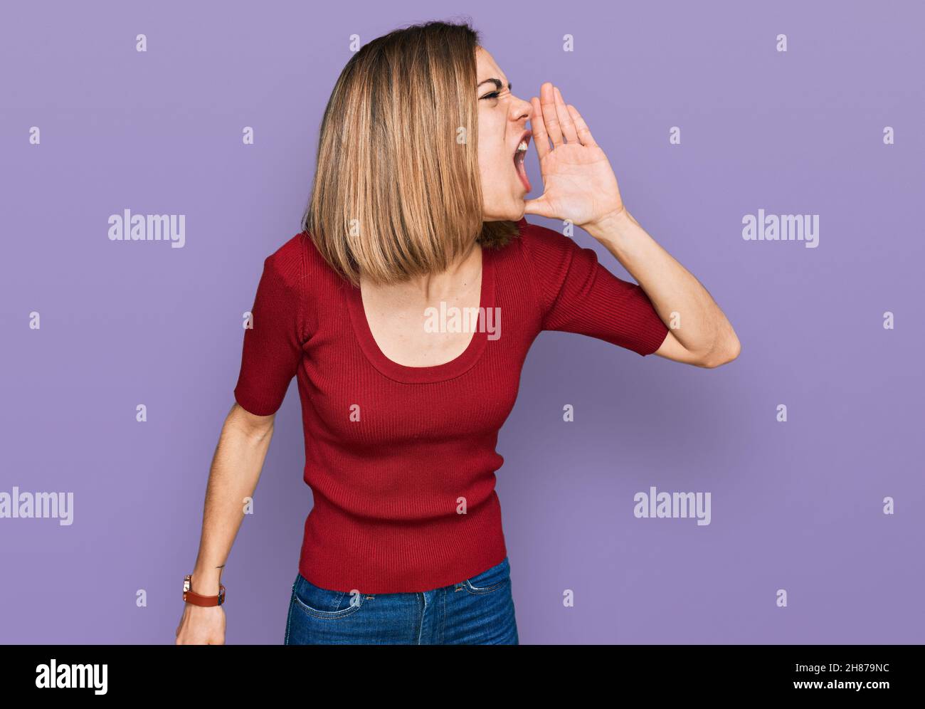Young blonde girl wearing casual clothes shouting and screaming loud to ...