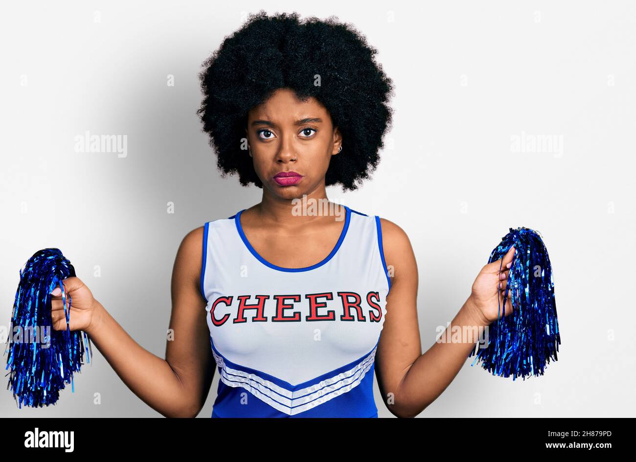 Young african american woman wearing cheerleader uniform using pompom ...