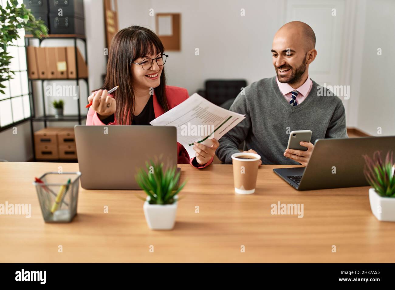 Two hispanic business workers smiling happy working using laptop and ...