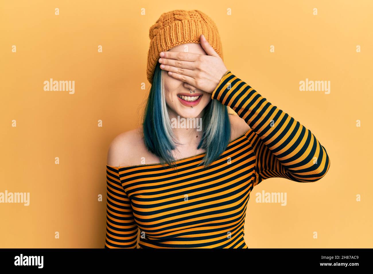 Young modern girl wearing wool hat smiling and laughing with hand on ...